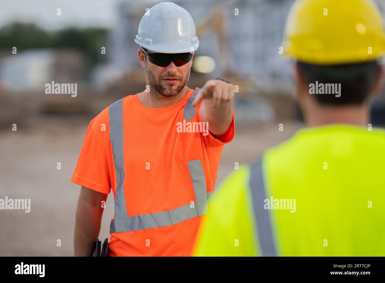 Construction site worker in helmet working outdoor. A builder in a ...