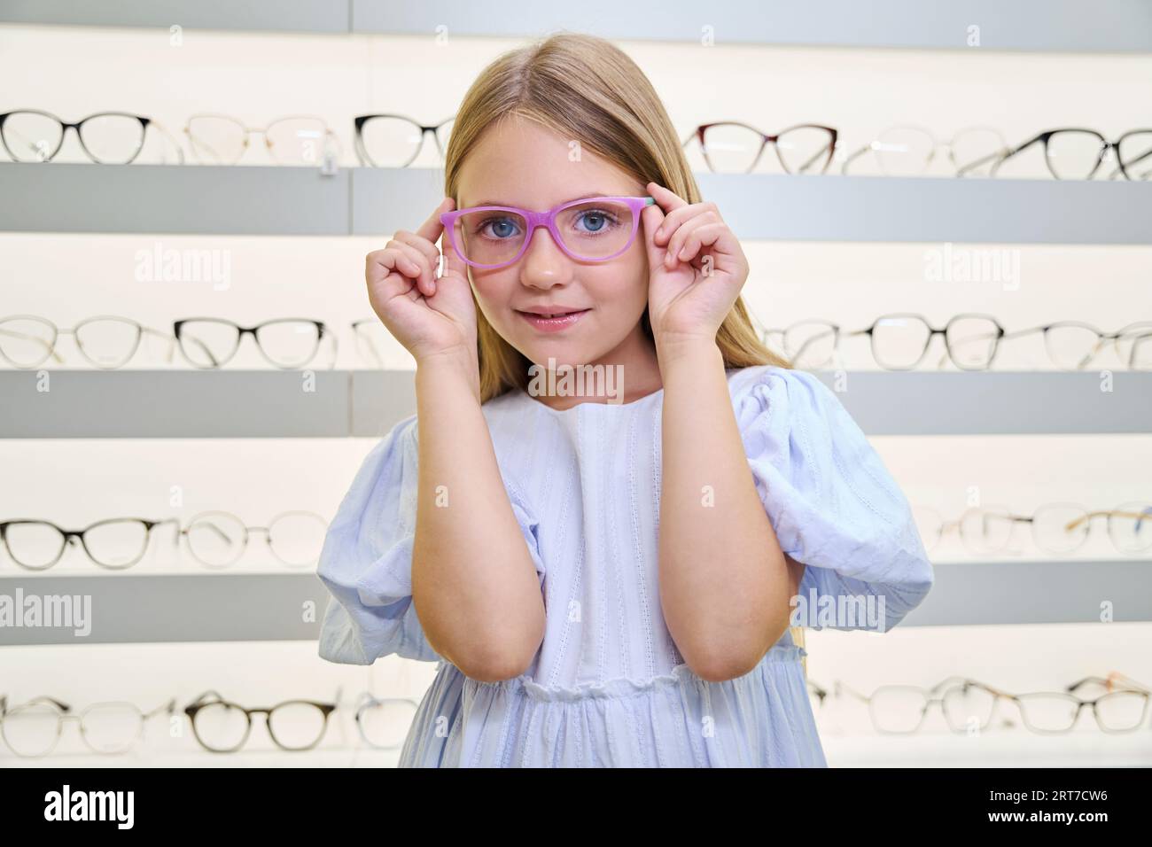 Little girl selecting new glasses in optical shop Stock Photo - Alamy