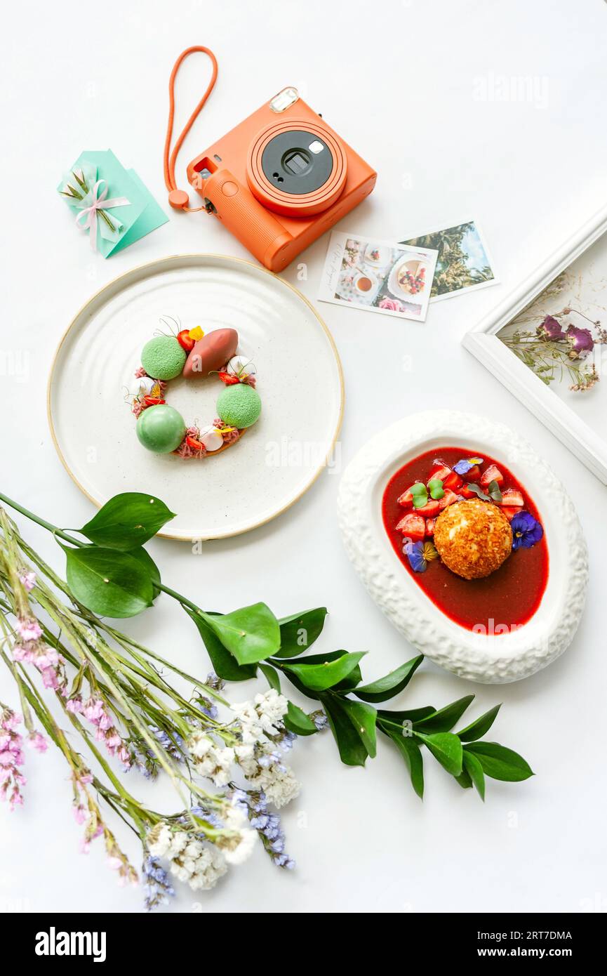 Background with desserts, polaroid camera and flowers. Top view on ...
