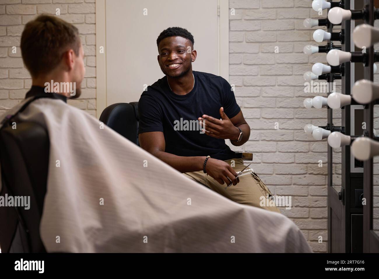 Cute African American barber interacting with a client Stock Photo - Alamy