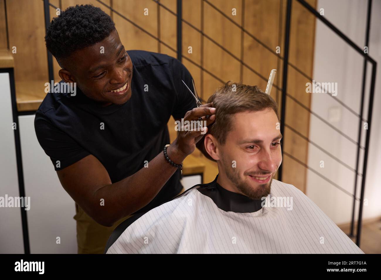 Friendly African American master makes a haircut for a client Stock ...