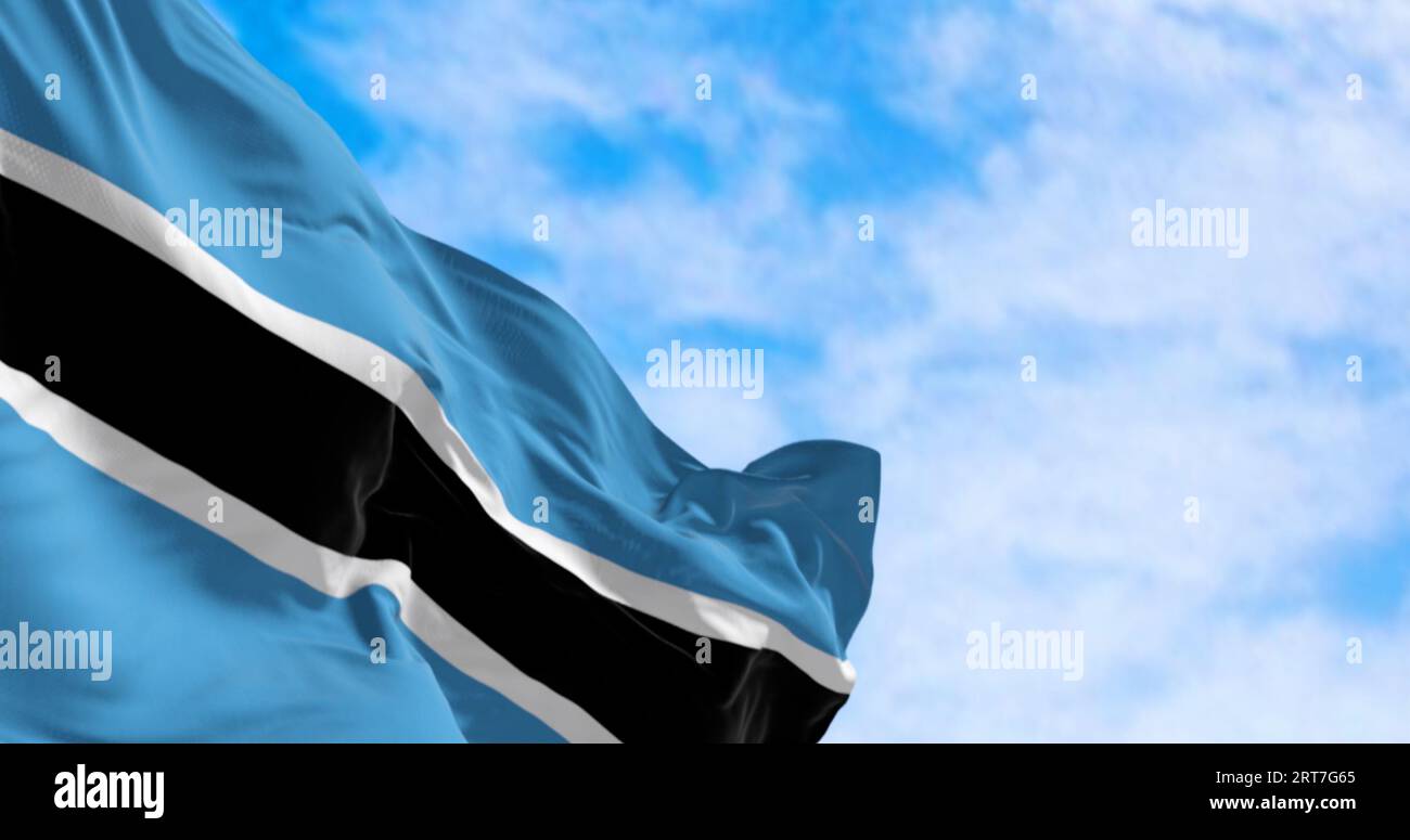National flag of Botswana waving in the wind on a clear day. Light blue field with a horizontal ...
