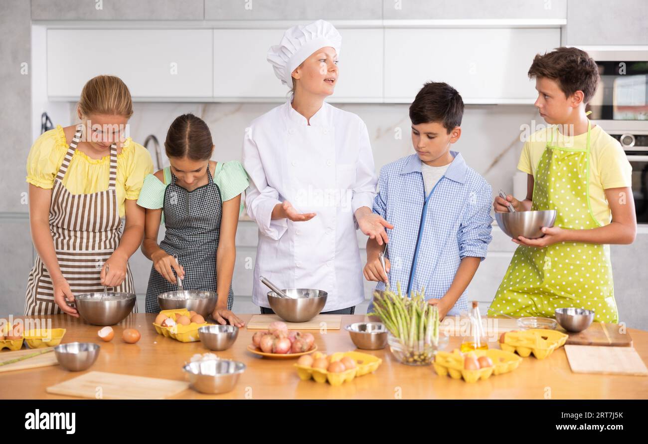 Adult woman cook teaches to cook group of children Stock Photo - Alamy