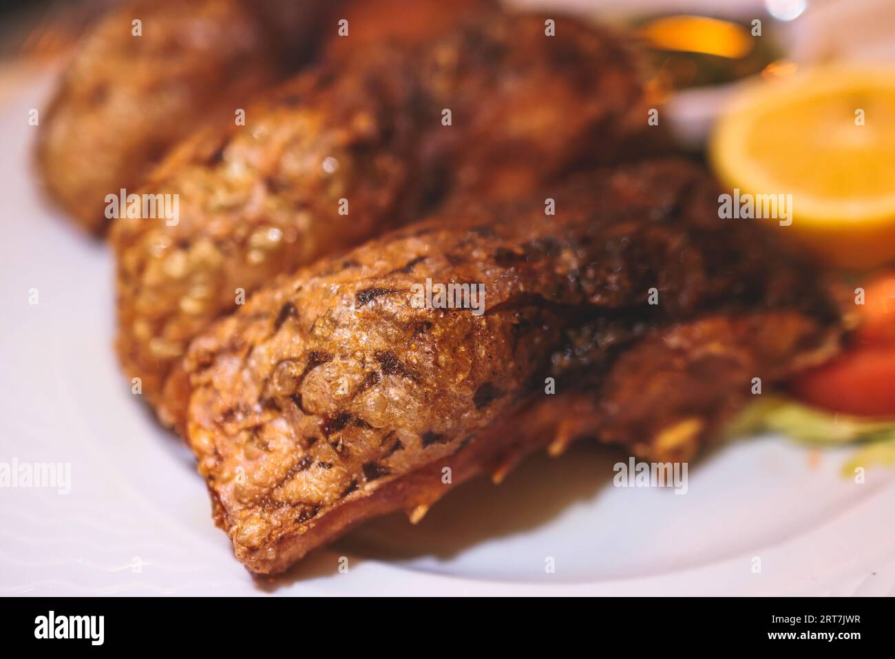 Fried grilled carp, roasted carp fish on plate with lemon and salad ...