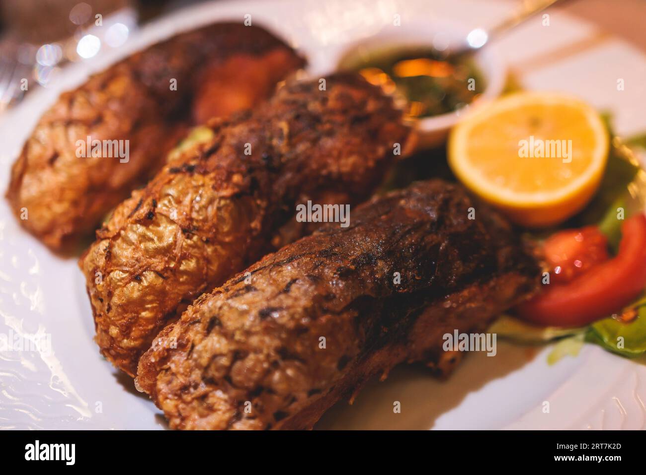 Fried grilled carp, roasted carp fish on plate with lemon and salad ...