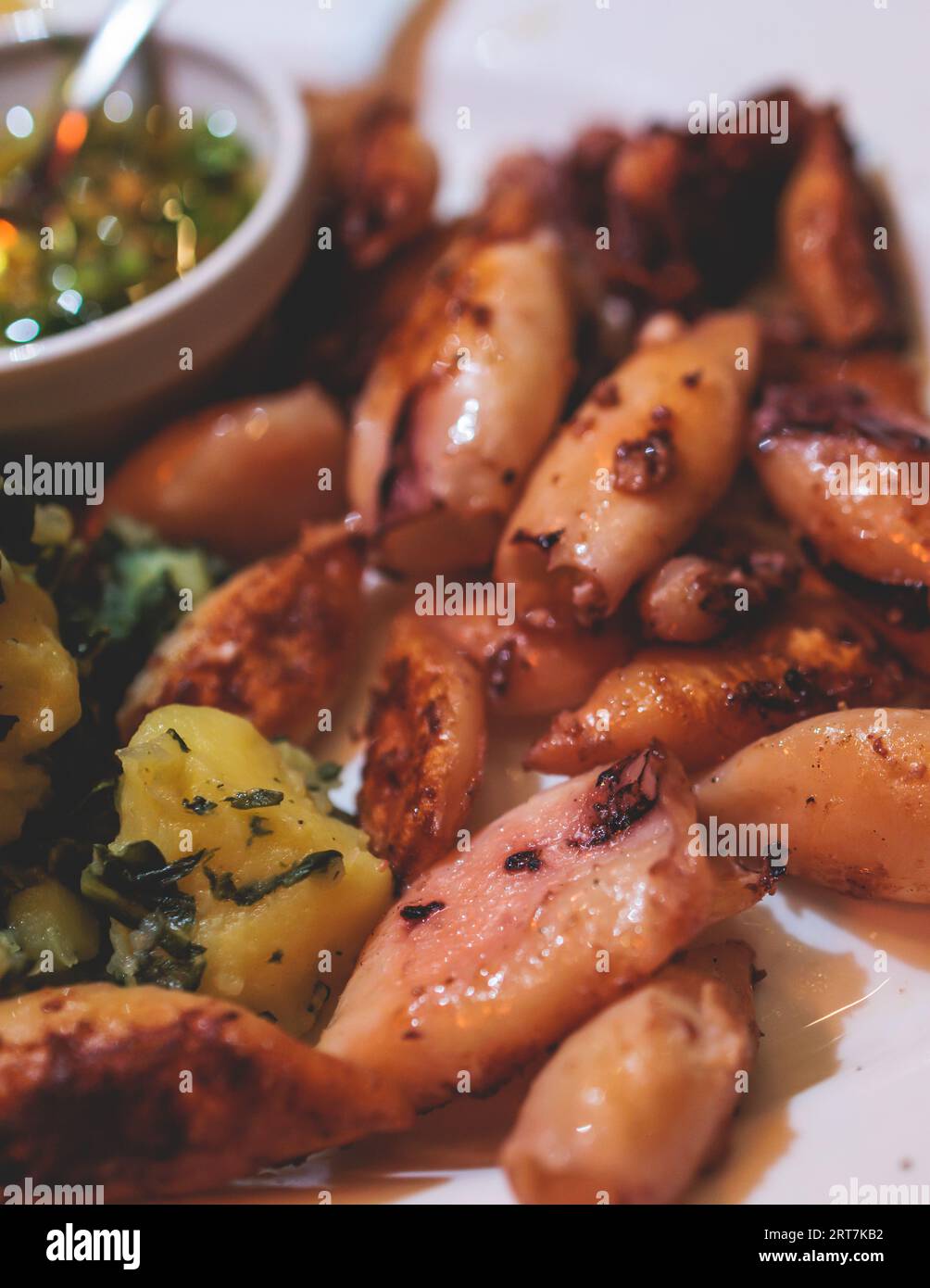 Fried grilled baby squids on a plate with garlic, lemon and mashed ...