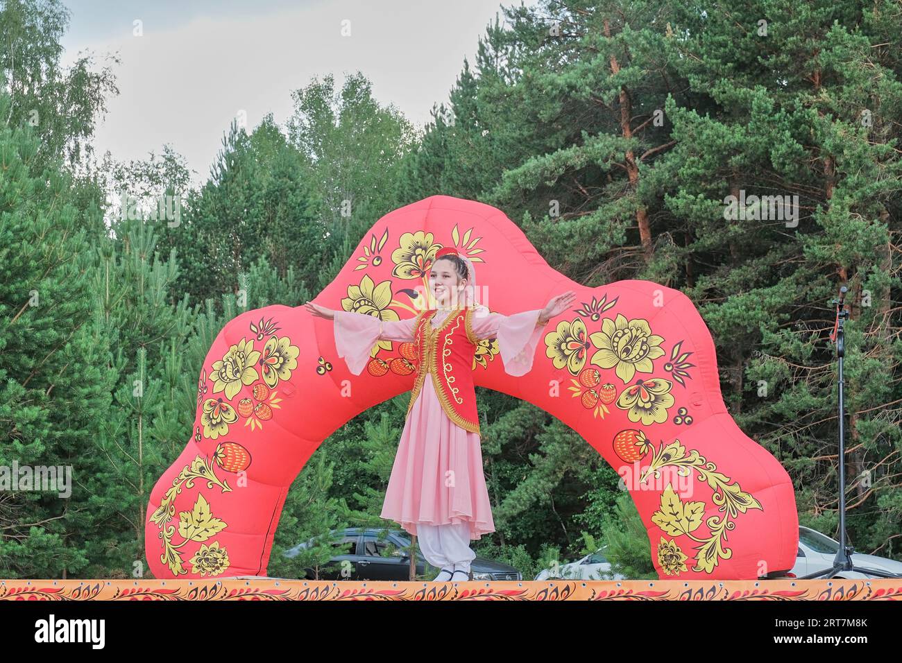 Sweet young smiling Asian dancing girl in skullcap and traditional ...