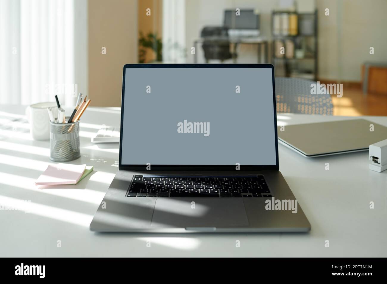 Laptop with empty screen on office desk Stock Photo - Alamy