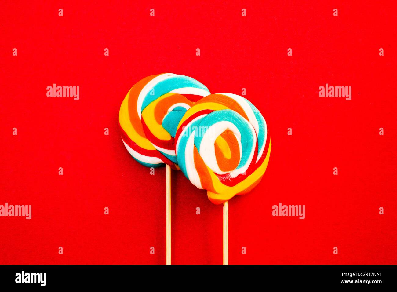 Colorful spiral lollipop candy on stick. On a red background Stock ...