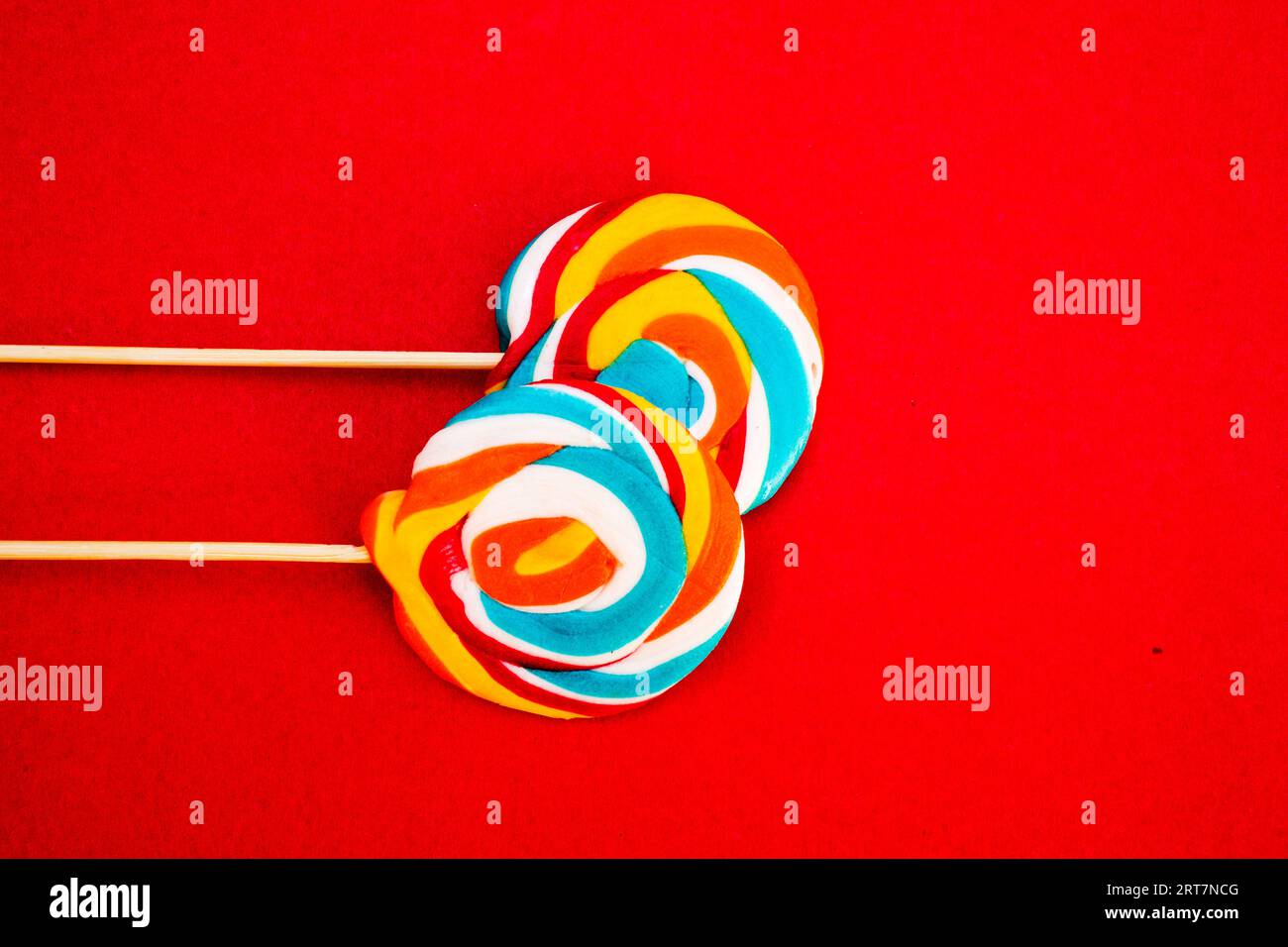 Colorful spiral lollipop candy on stick. On a red background Stock ...