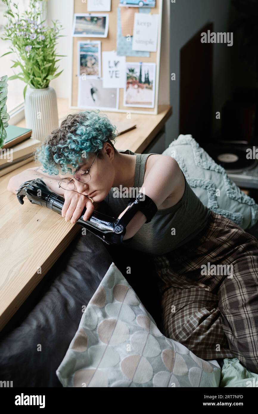 Vertical image of sad girl with disability spending time alone at home ...