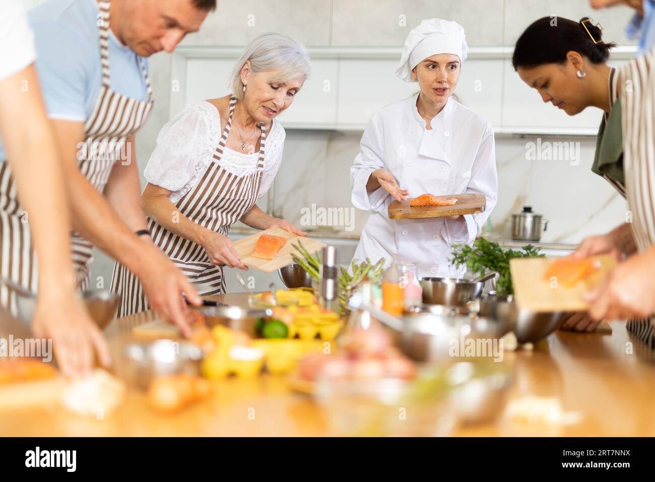Female chef sharing secrets of cooking salmon at culinary class Stock ...