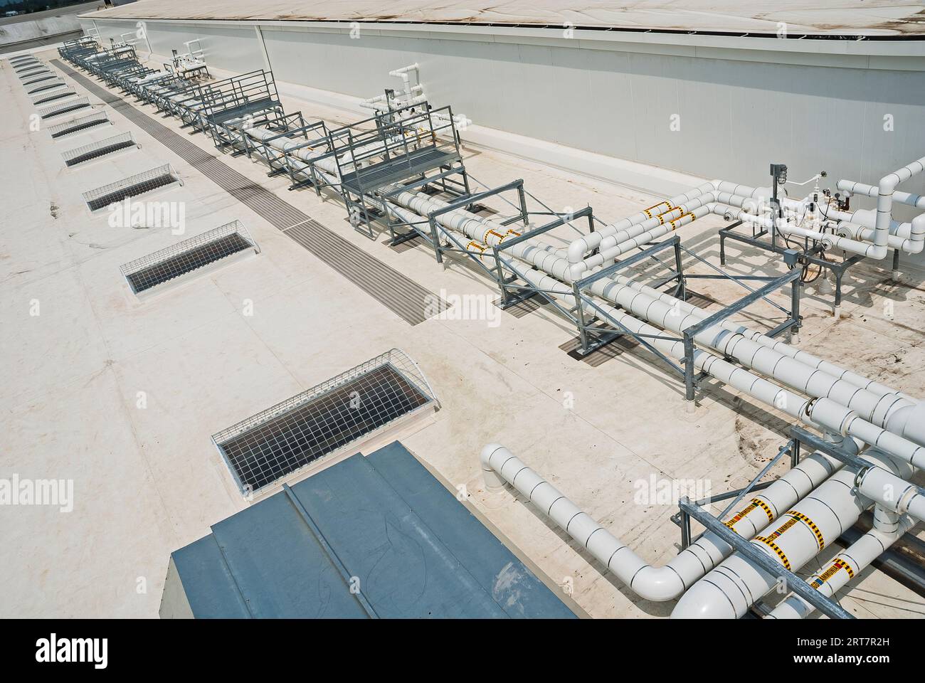 White insulated piping mounted on roof of cold storage facility, for ...