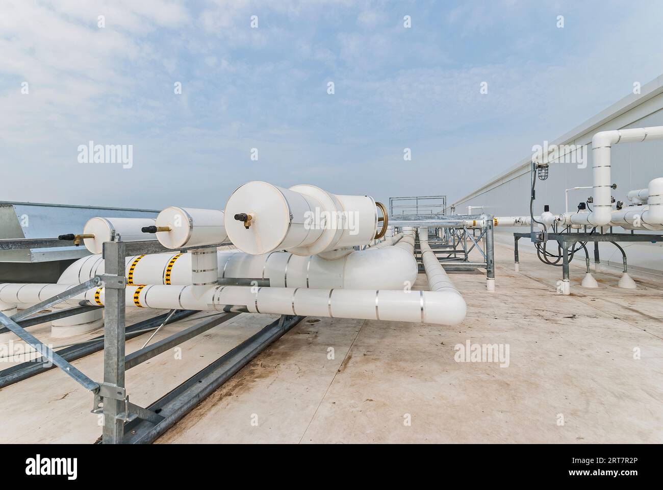 White insulated piping mounted on roof of cold storage facility, for ...