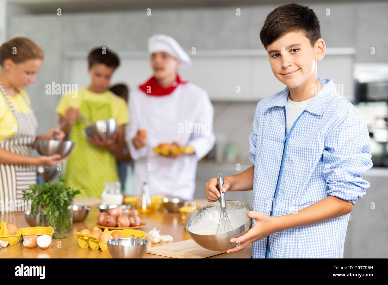 Interested tween boy attending group culinary classes for children ...