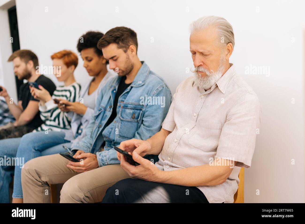 Side view of bored multicultural and different ages business people ...