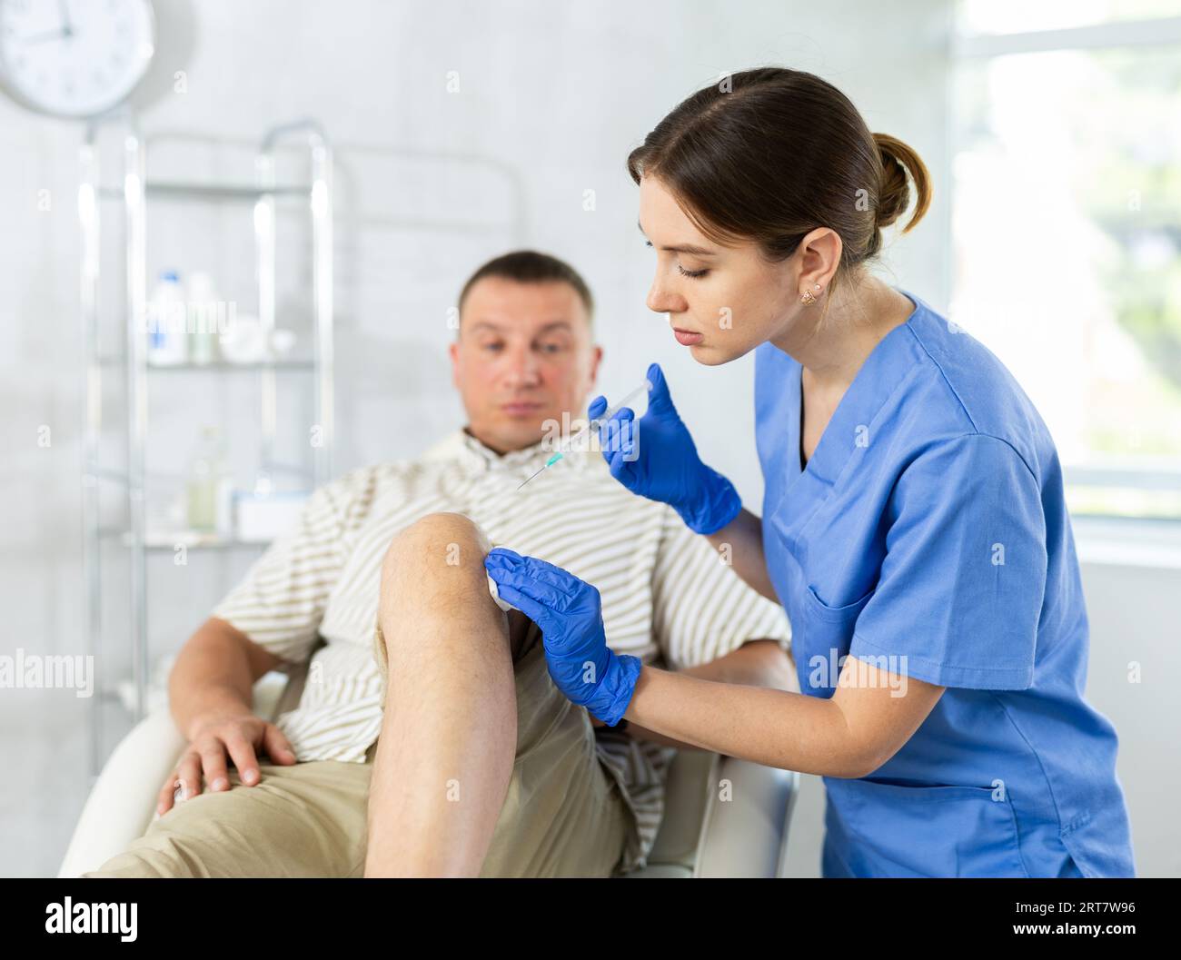 Man at surgeon appointment - woman makes an injection of medicine into ...