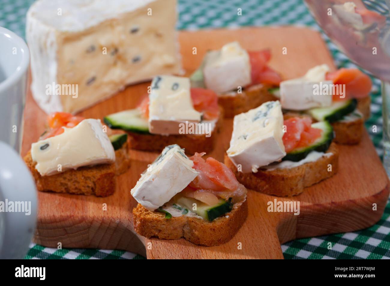 Canape from soft cheese, cucumber and salmon at bread, served on desk ...