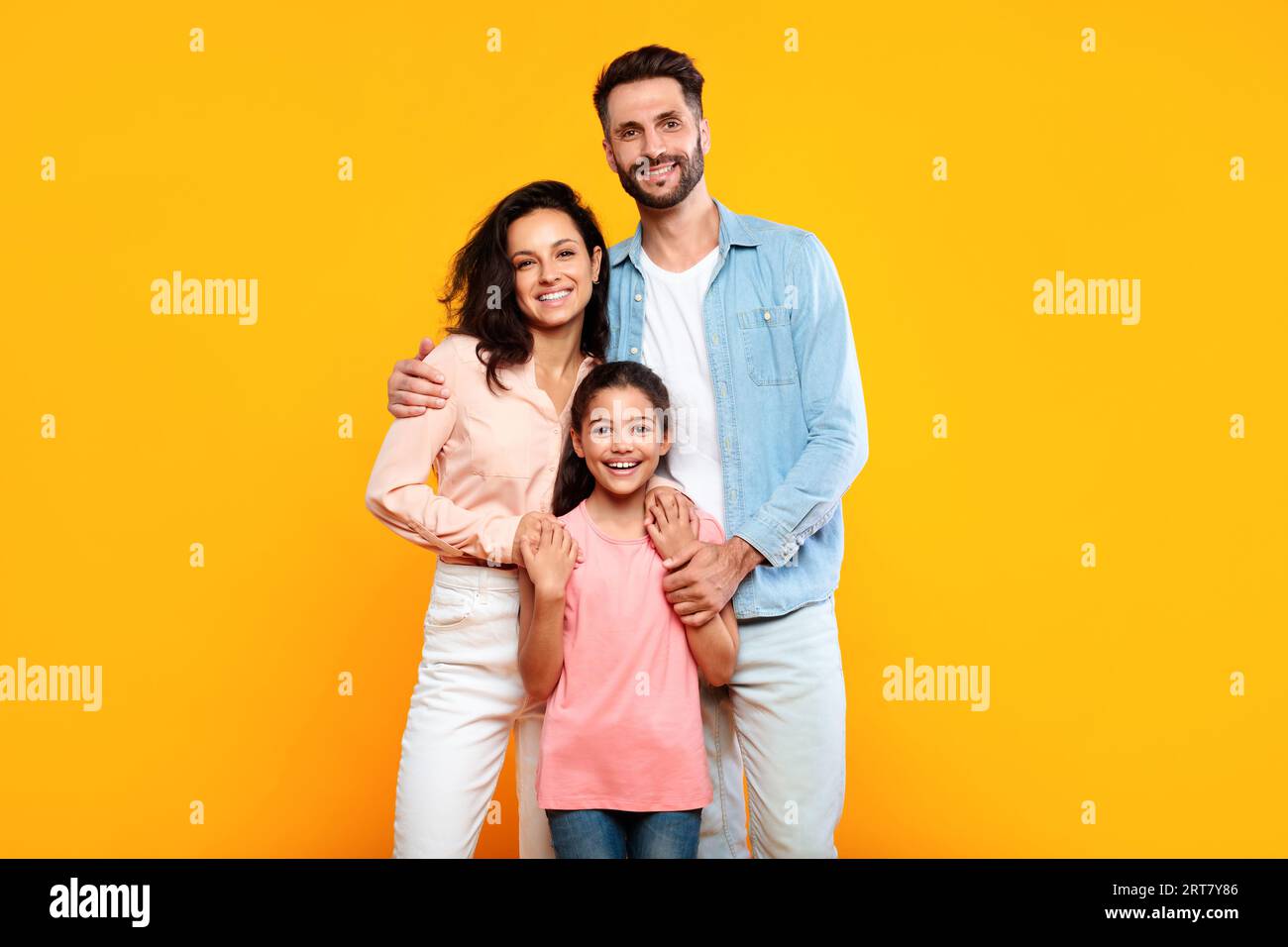 Happy european family of three hugging and smiling to camera, posing ...