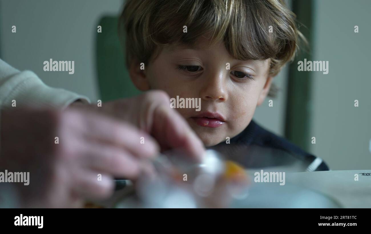 Hand feeding food to small boy, close-up face of a caucasian male child ...