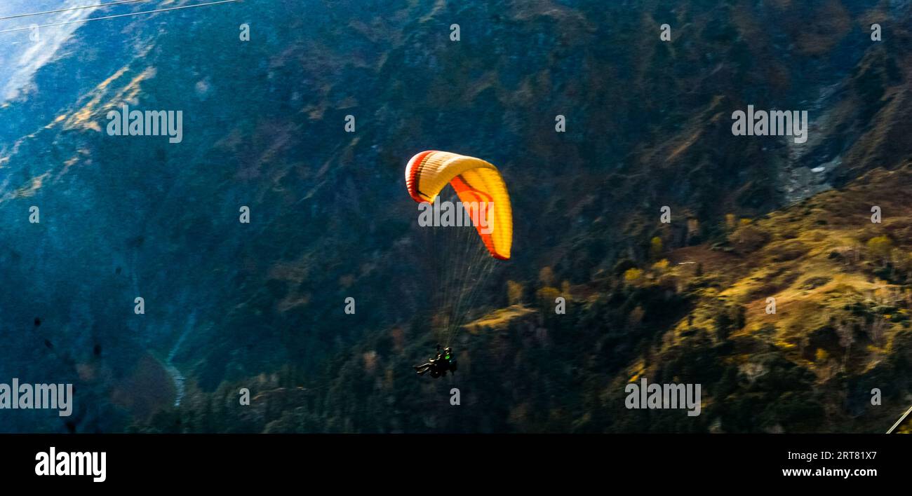 A parachute flying against mountain background Stock Photo - Alamy