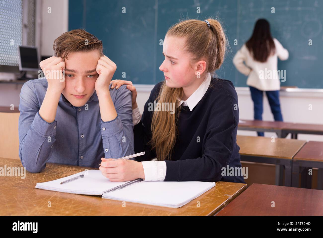 Female classmate calming frustrated teenager Stock Photo - Alamy