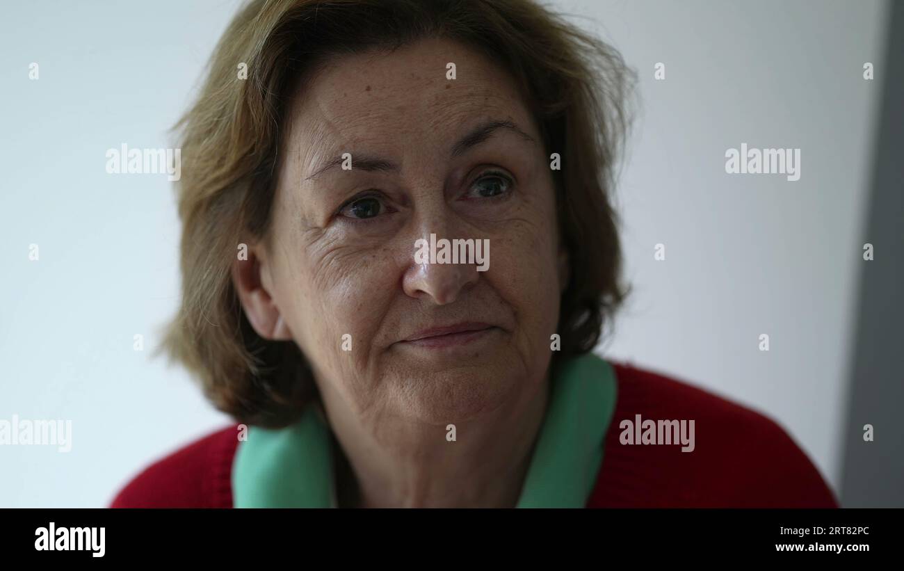 Elderly Woman Smiling and Attentively Listening to Off-Camera Friend ...