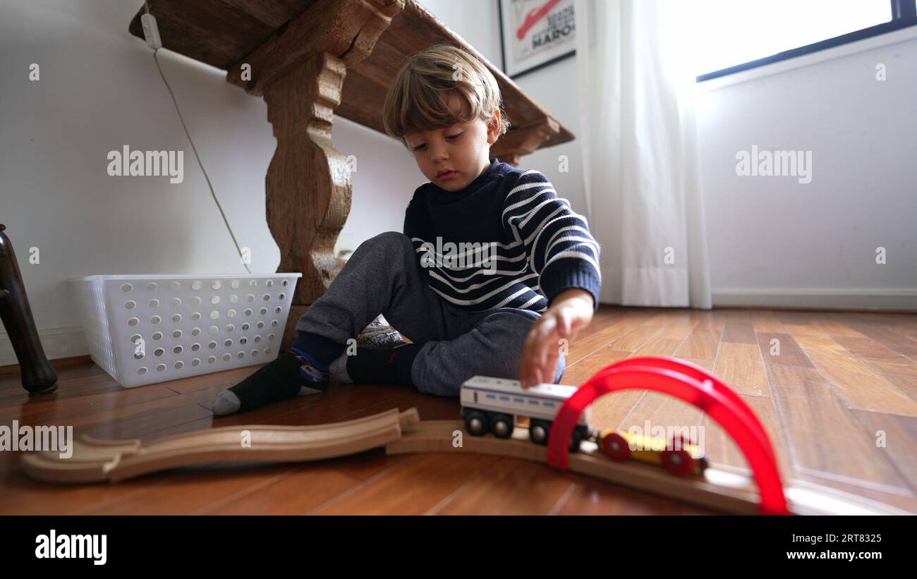 Child plays with retro vintage train toys on wooden tracks, one ...