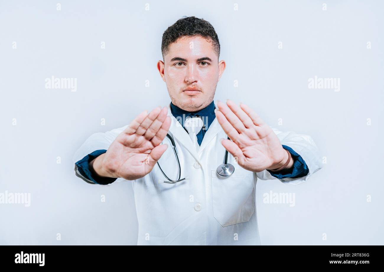 Doctor making a stop gesture with palms on white background. Latin ...