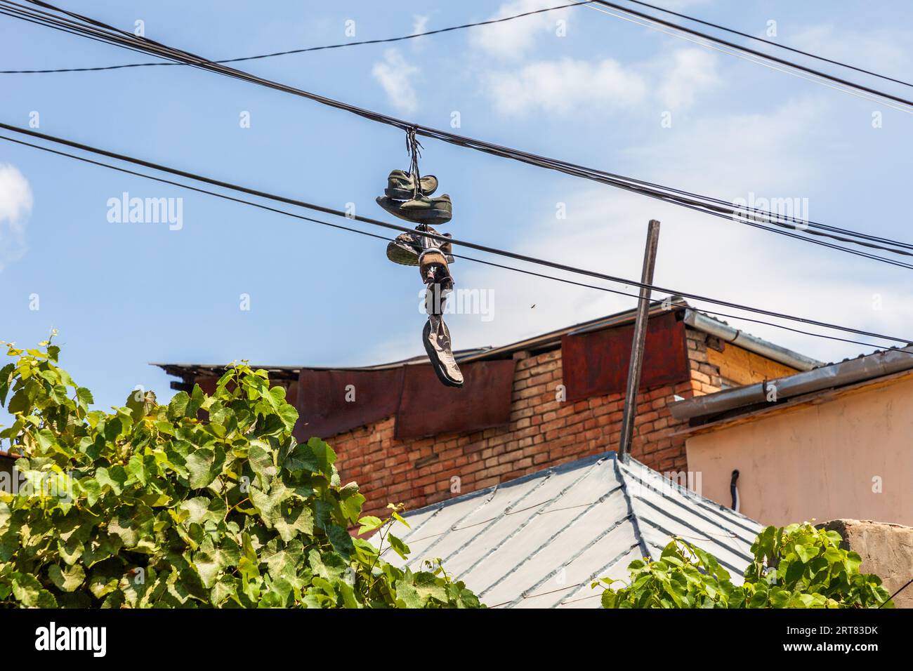 Several pairs of shoes hanging from power lines. In Chugureti, Tbilisi ...