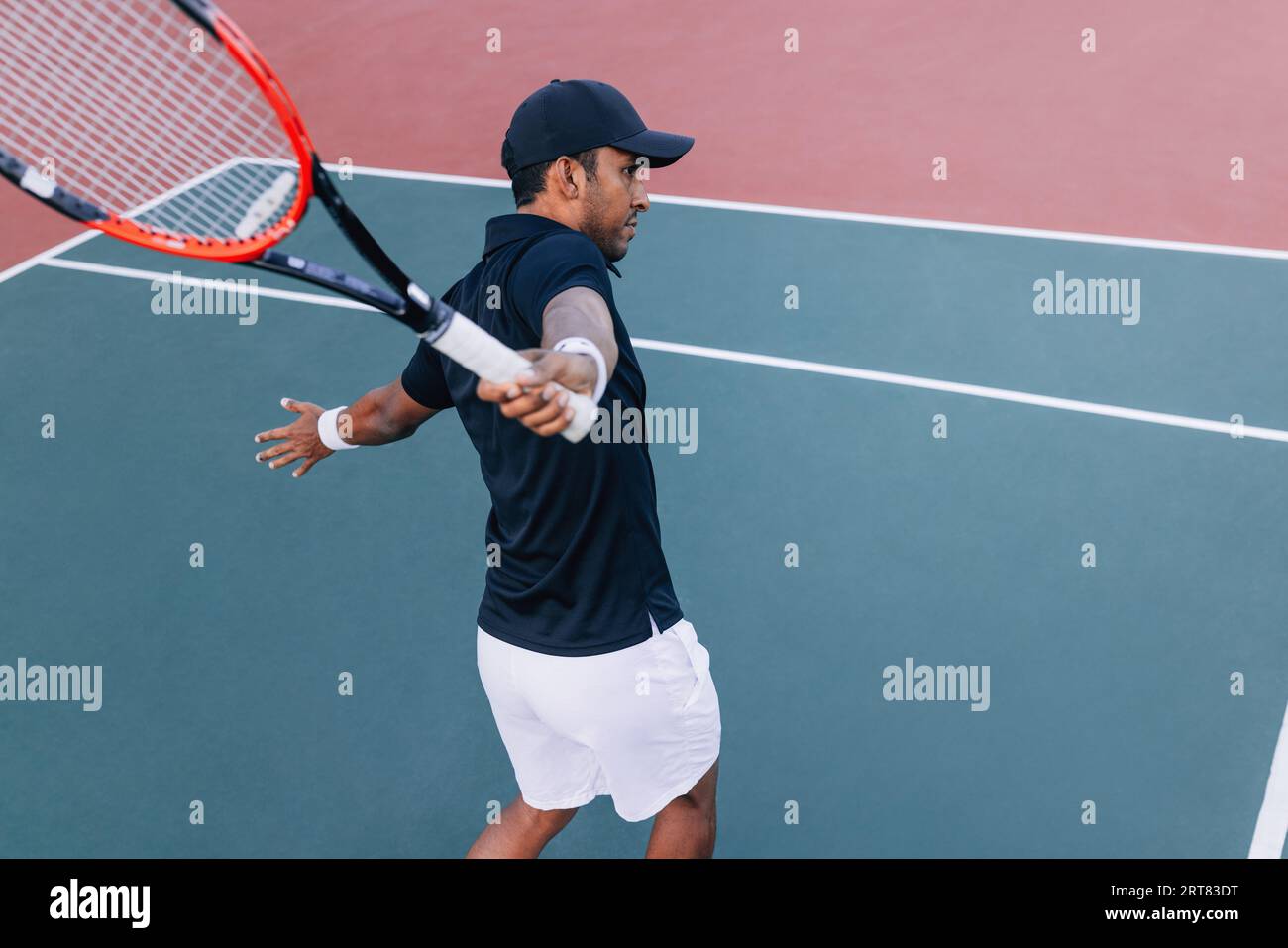 Professional tennis player practicing one-handed backhand hit on hard ...