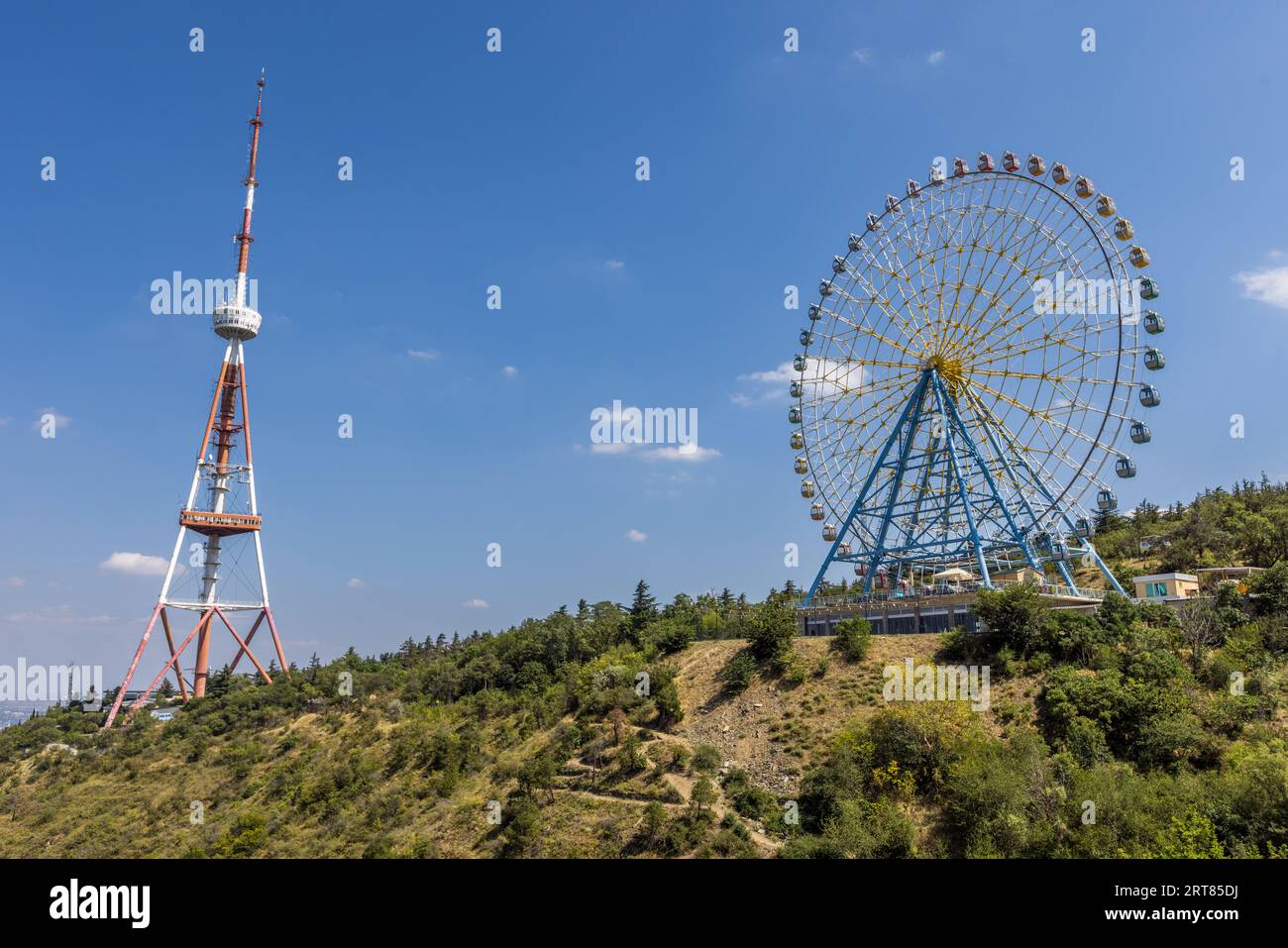 The Tbilisi television tower and a Ferris wheel stand on a hill above ...
