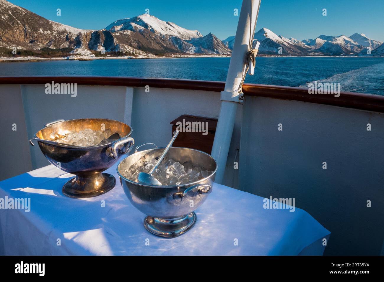 Two metal bowls with ice cubes standing on table on deck of cruise ship ... Two metal bowls with ice cubes standing on table on deck of cruise ship ...