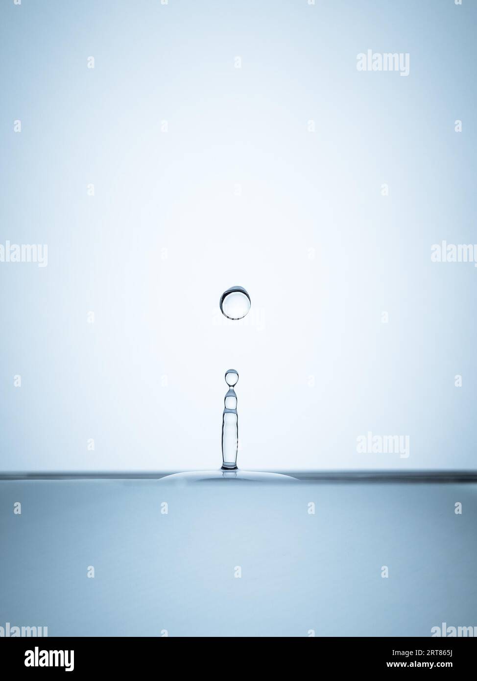 Detail of water drops falling hitting the surface of water isolated on ...