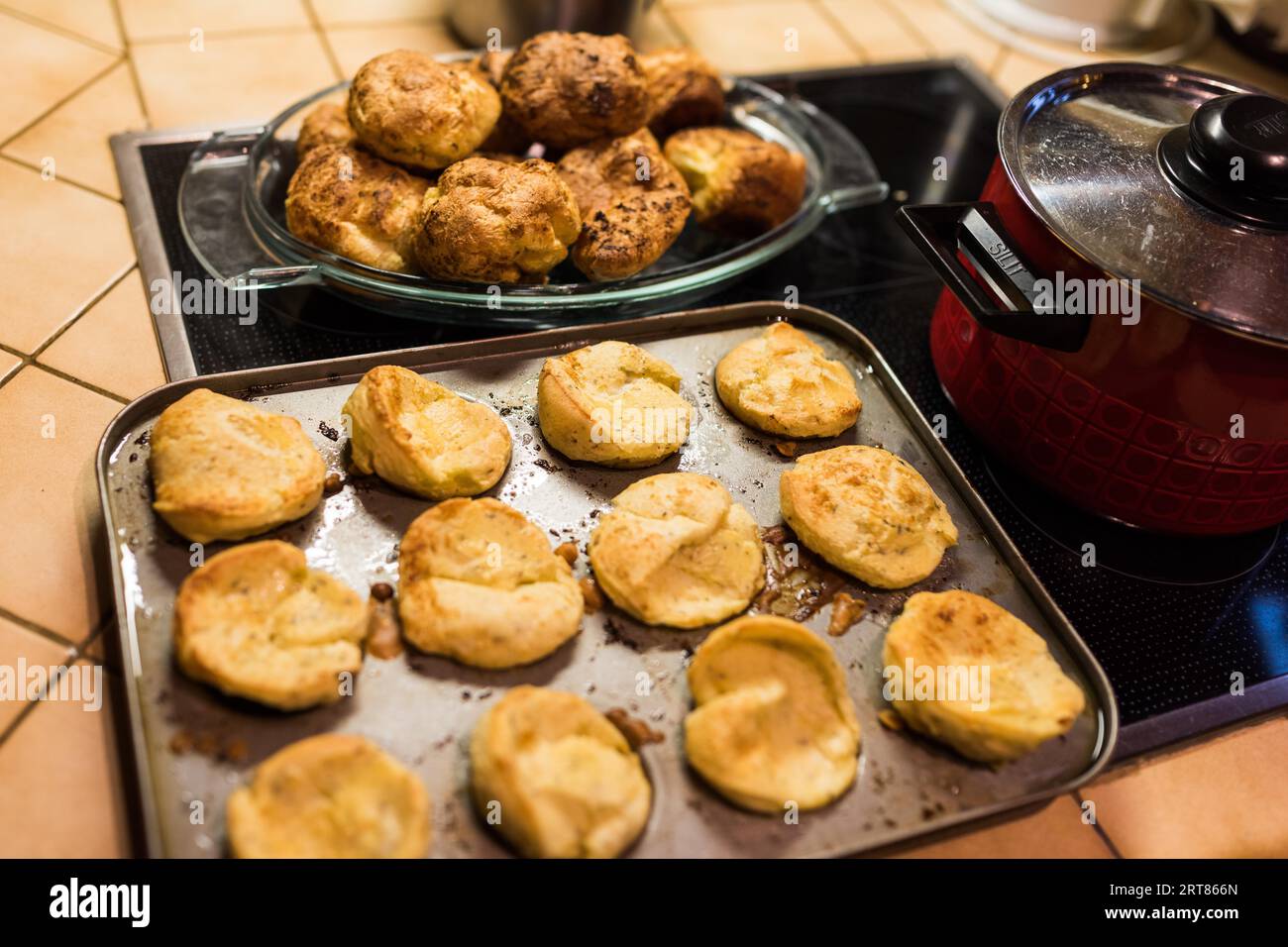 Preparing Yorkshire Puddings in muffin form standing on oven in kitchen ...