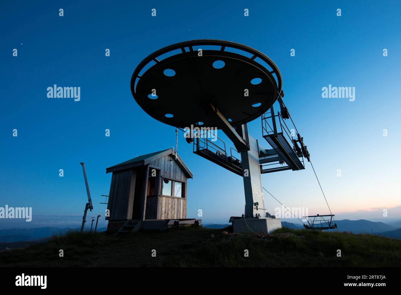 A lonesome ski lift and building under a summer starry sky at Mt Buller ...