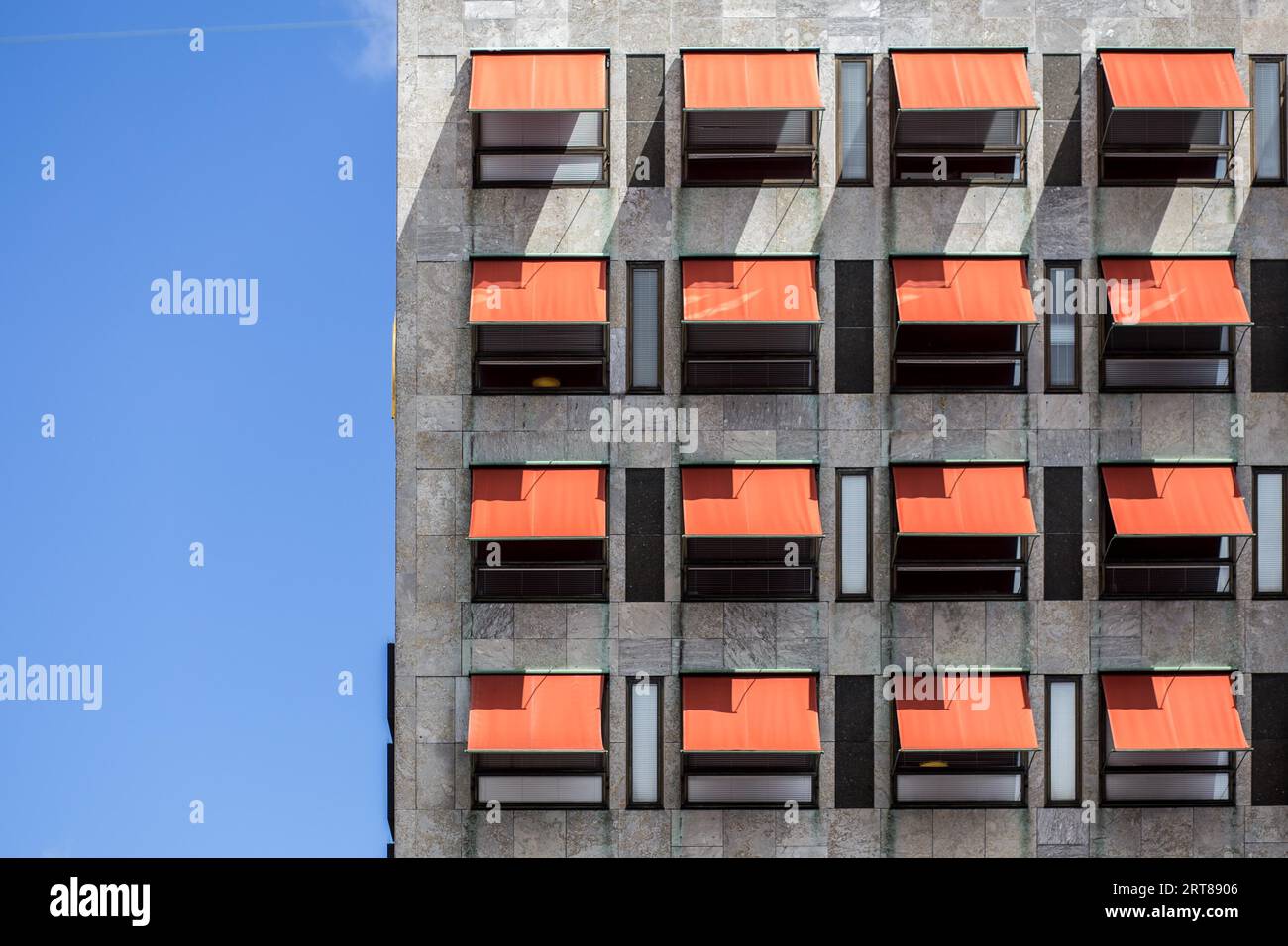 Many red awnings over windows on a office building Stock Photo - Alamy