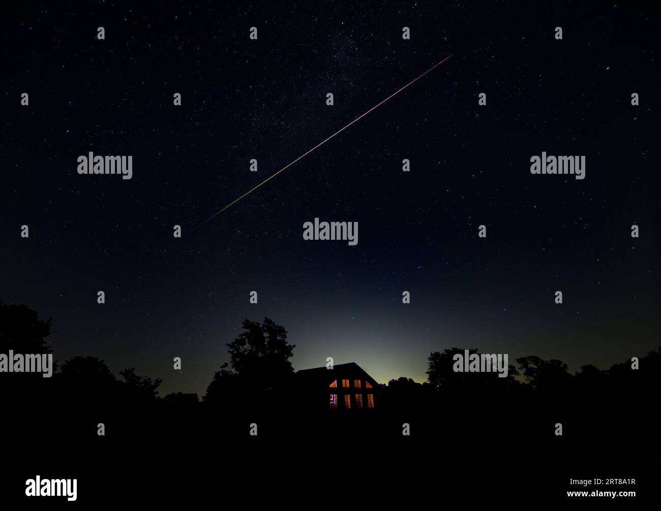 Amazing green and pink meteor trail streaking across night sky over a ...