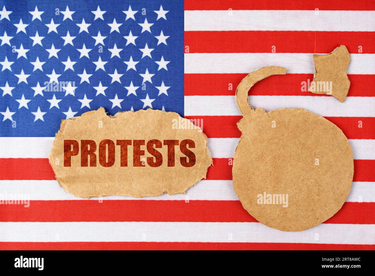 On the flag of the United States are a bomb cut out of cardboard and a ...