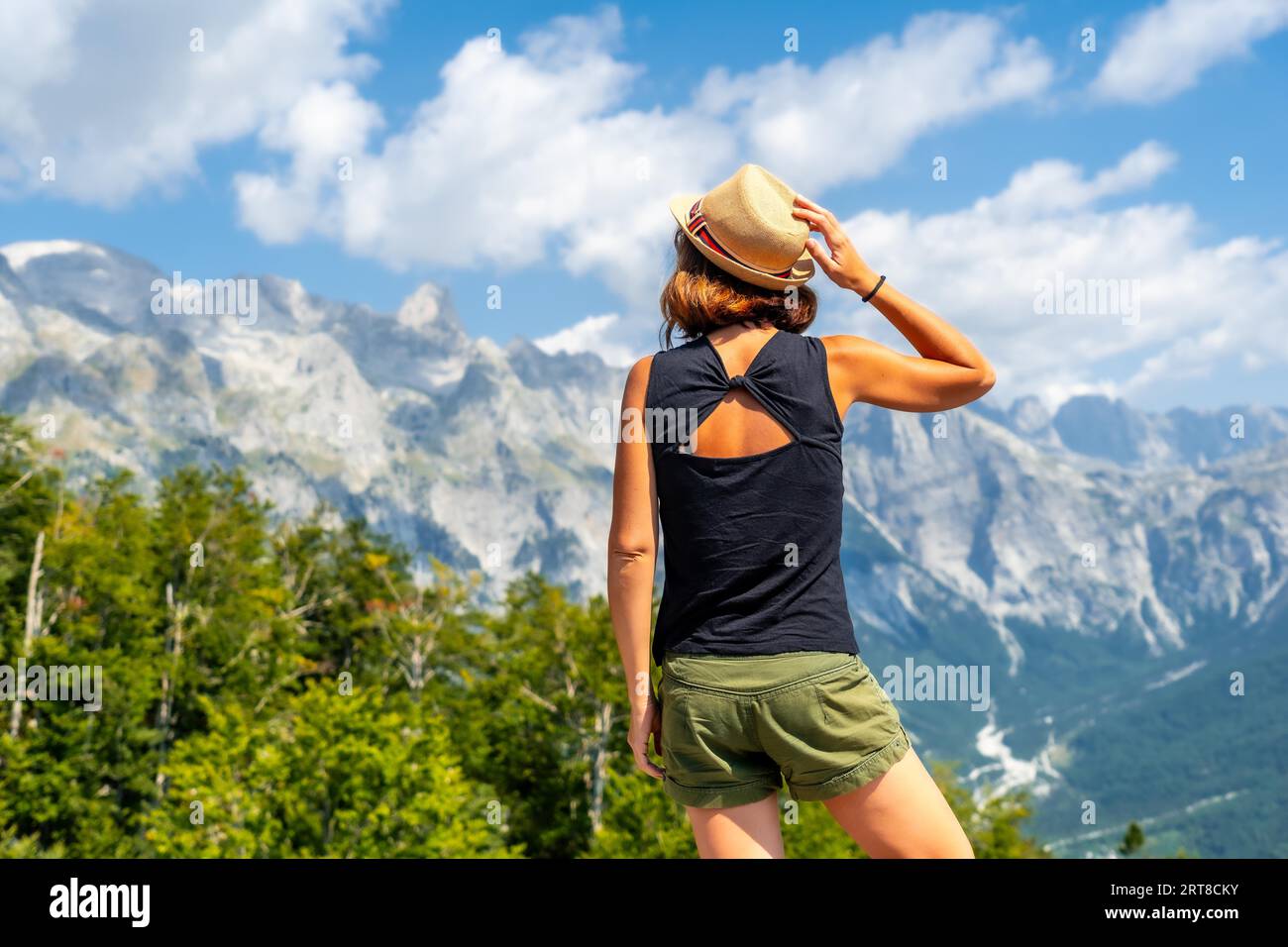 A tourist woman with hat on the mountain peaks of Theth national park ...