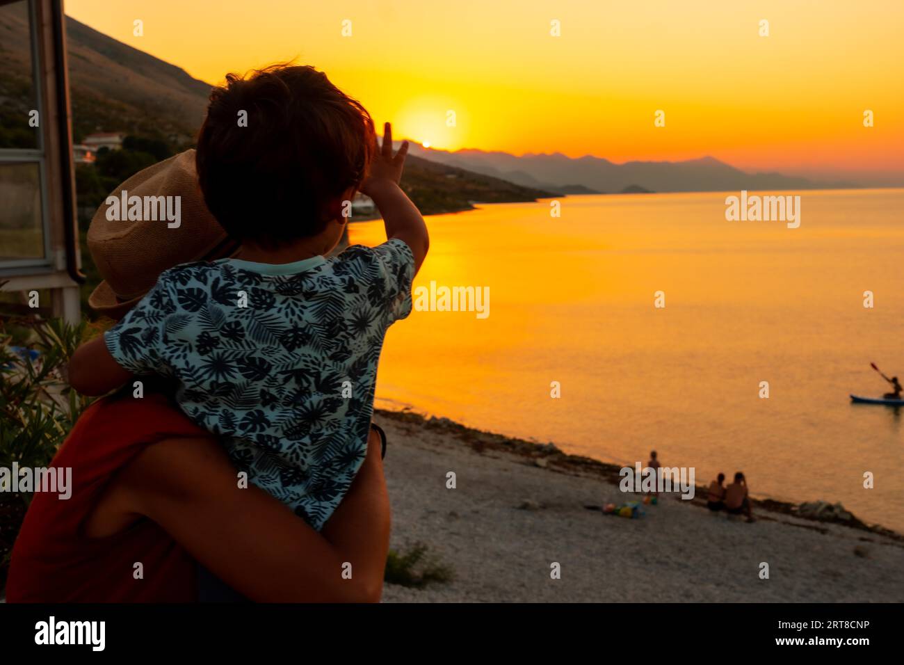 Mother and son saying goodbye to the sun at sunset at Shkoder lake in ...