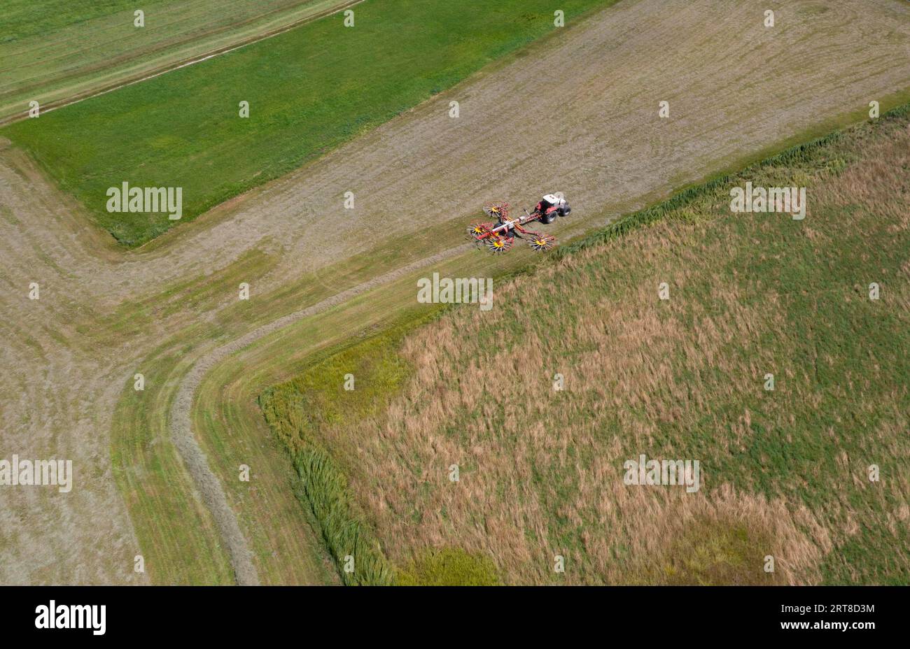 Drone view of a tractor turning hay in the field, Flachgau, Land ...