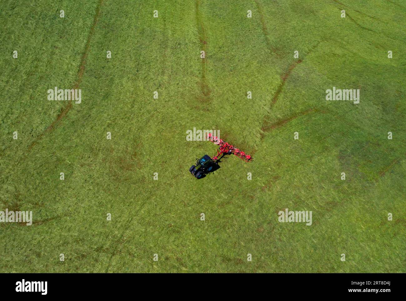Drone view of a tractor turning hay in the field, Flachgau, Land ...