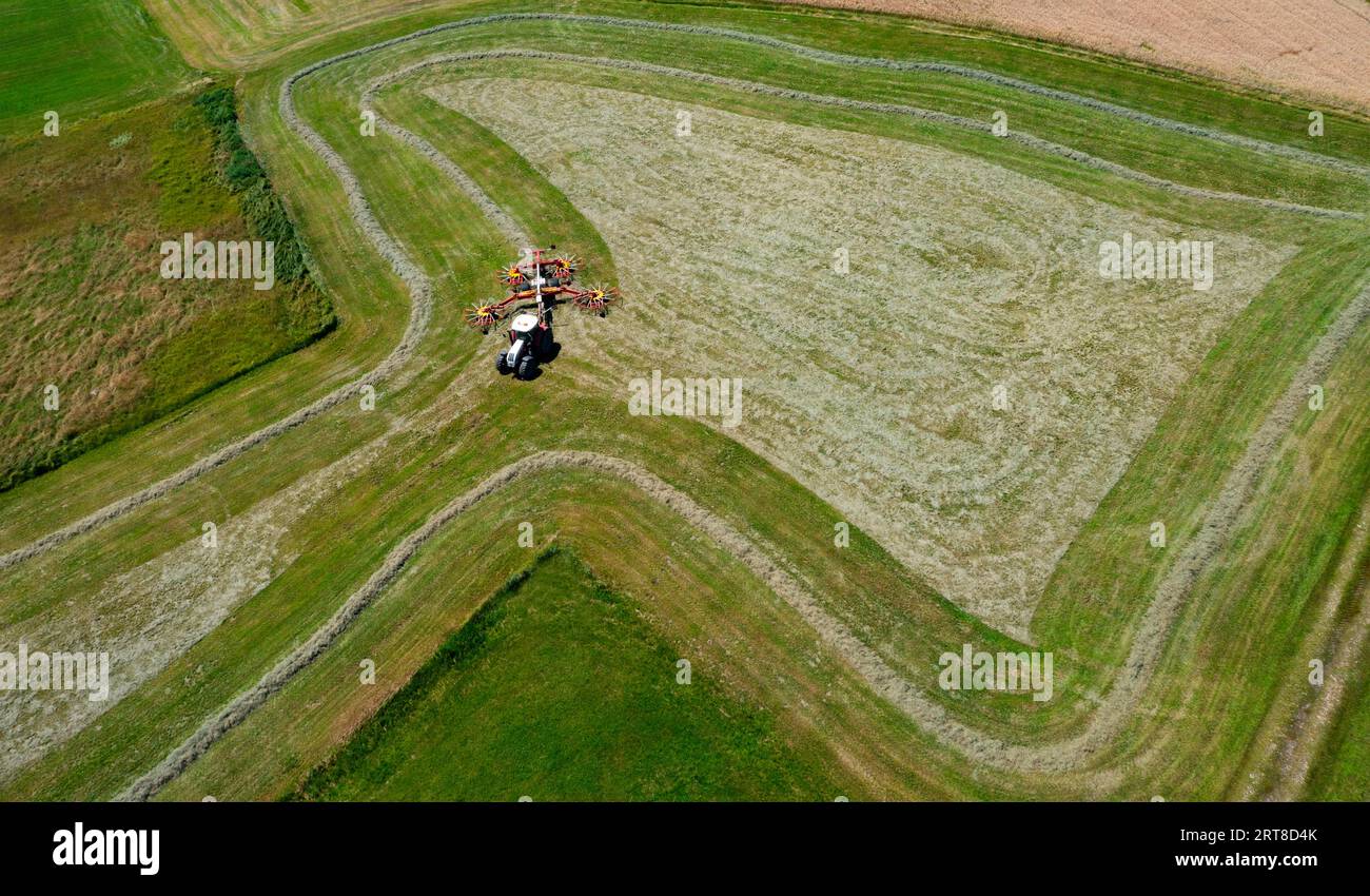 Drone view of a tractor turning hay in the field, Flachgau, Land ...