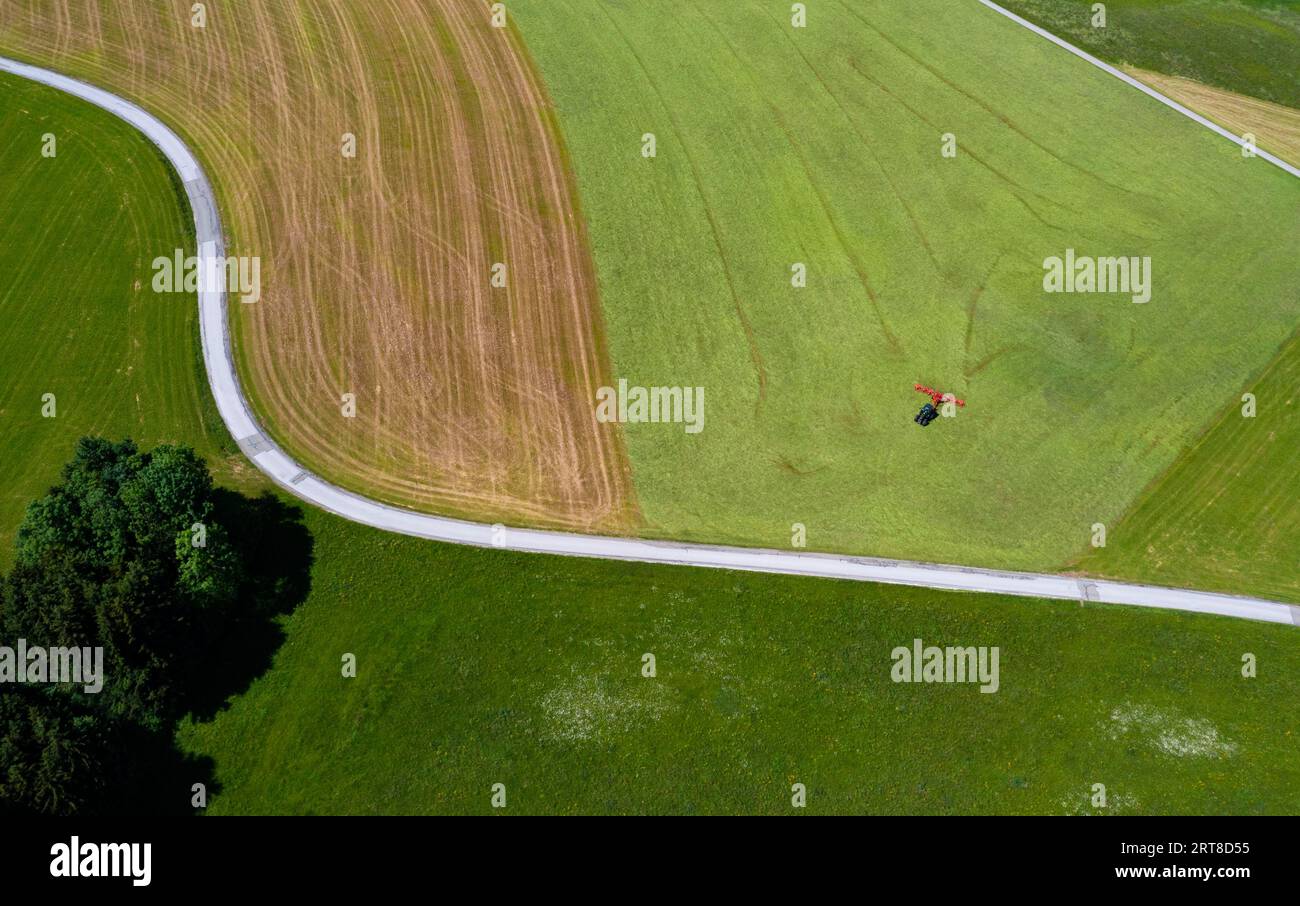 Drone view of a tractor turning hay in the field, Flachgau, Land ...