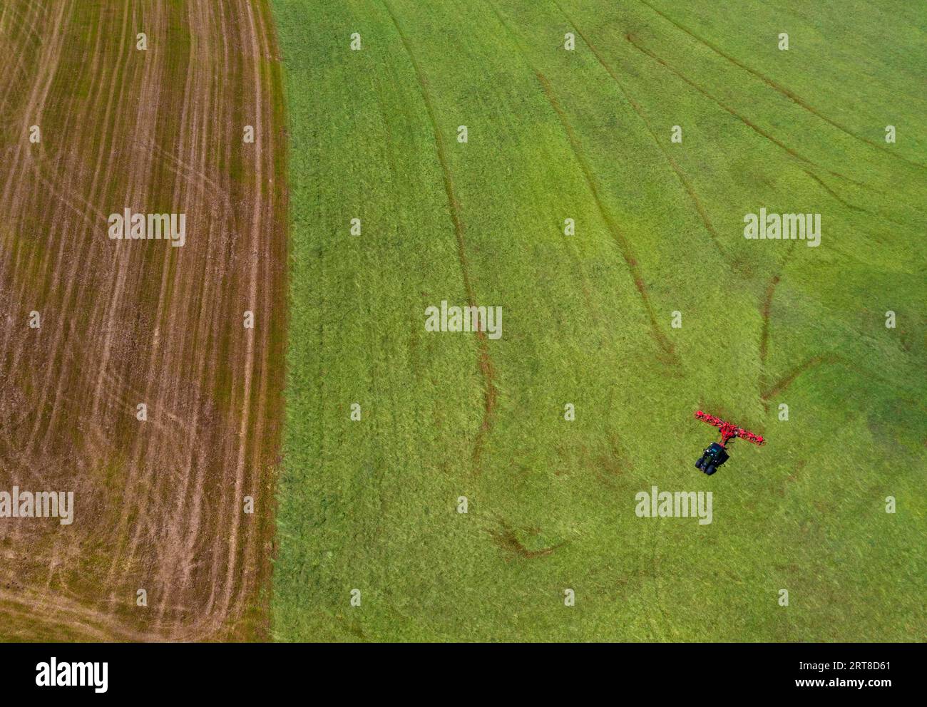 Drone view of a tractor turning hay in the field, Flachgau, Land ...