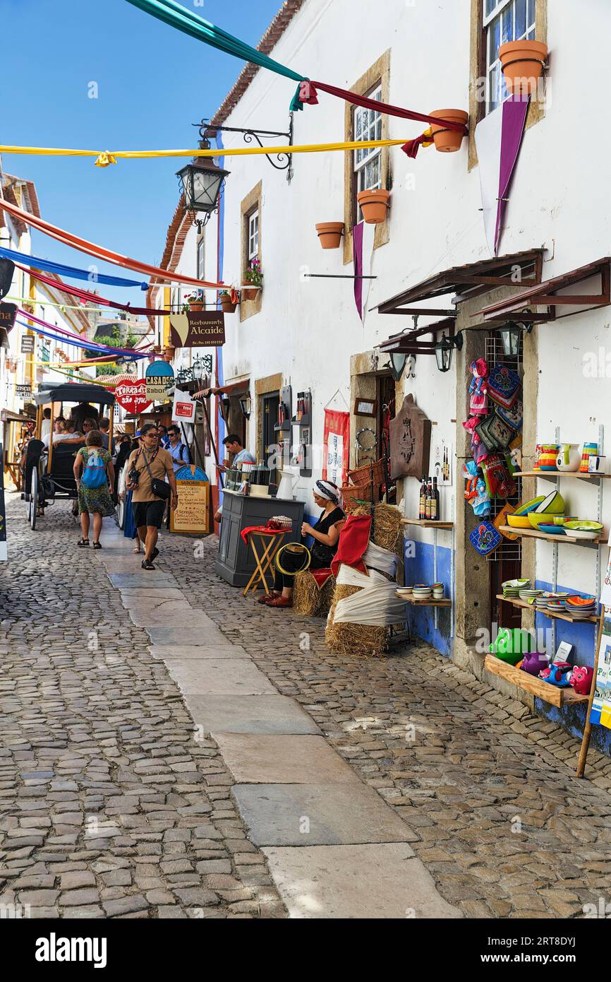 Picturesque alley with shops and pedestrians, tourists in the medieval ...