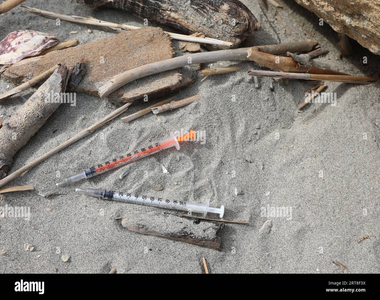 two used disposable syringes abandoned on the sandy beach Stock Photo ...