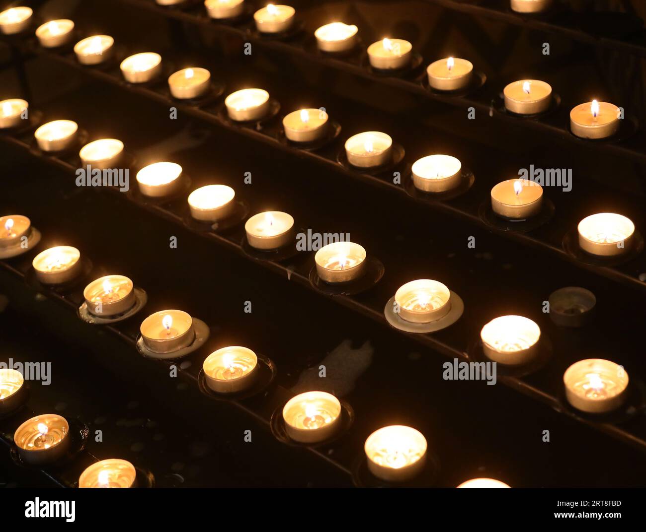 votive candles with the flame by pilgrims during the religious service ...