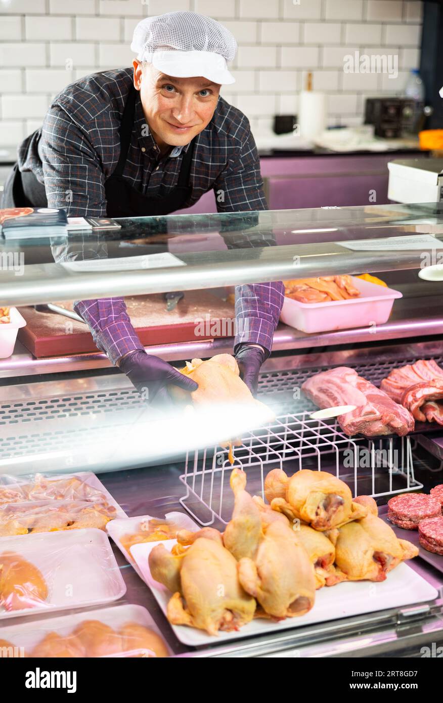 Adult butcher showing fresh gutted chickens in butchery Stock Photo - Alamy
